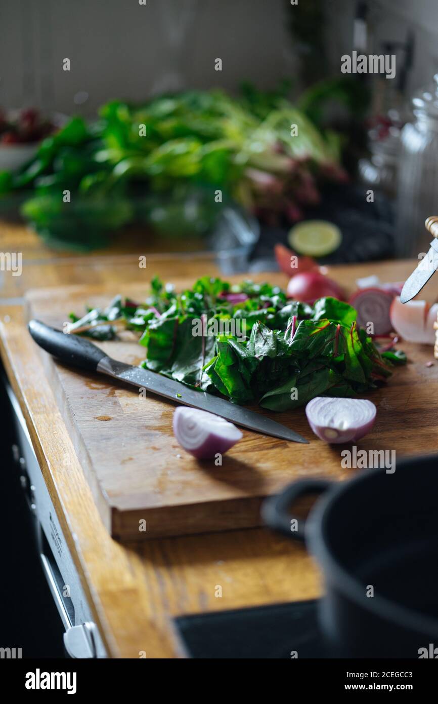 Crop female hands chopping green leaves of herbs on wooden cutting ...