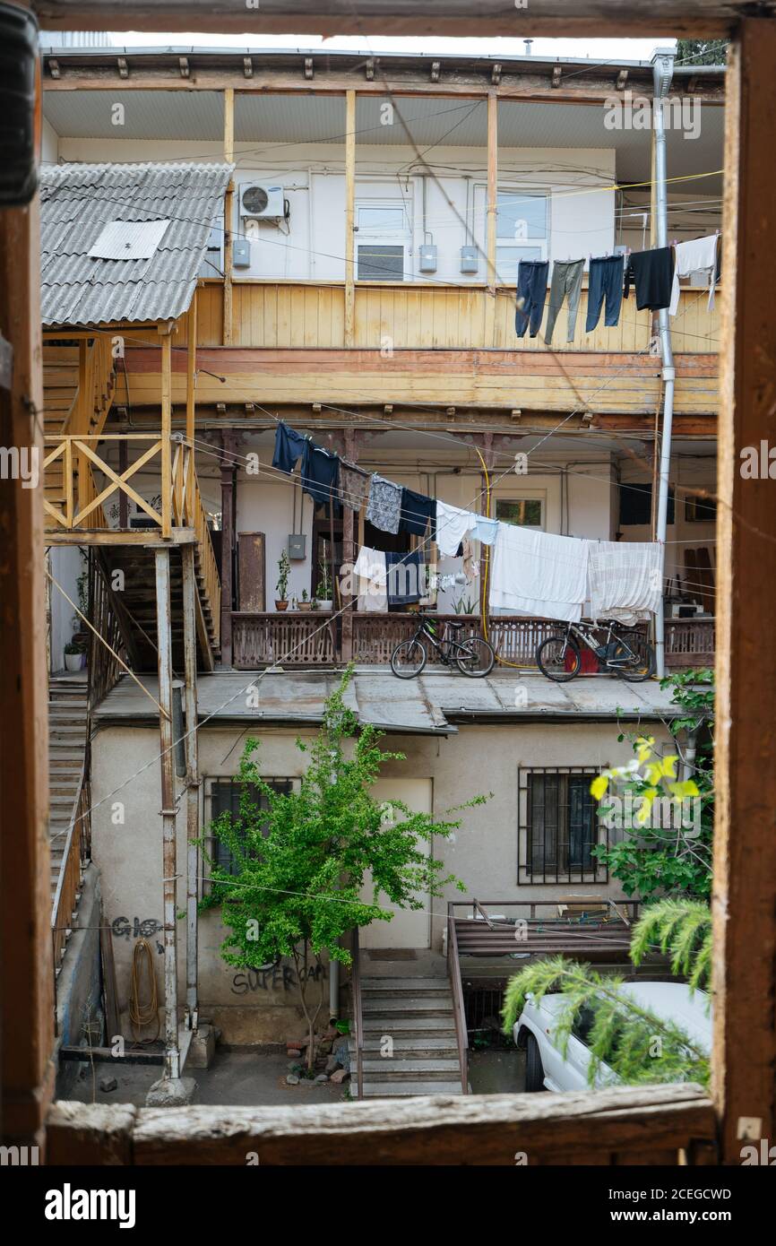 View through old window of worn out withered house with freshly built ...
