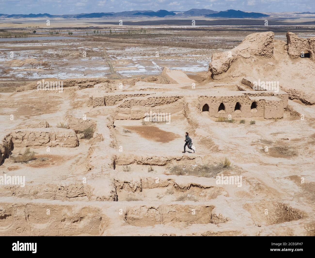 Side view of man running on remnants of ancient stone building in ...