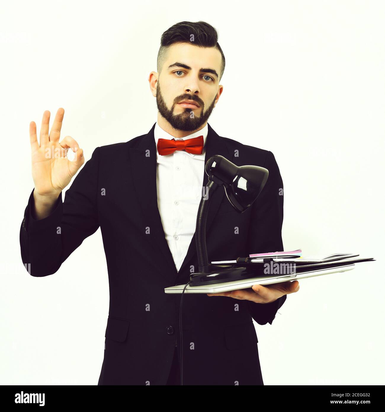 Insurance agent showing OK sign holds office desk appliances and wears ...