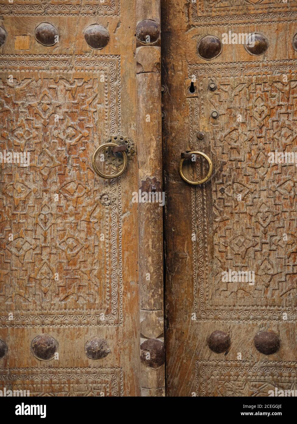 Close-up shot of old wooden door with ornamental carving and metal ...