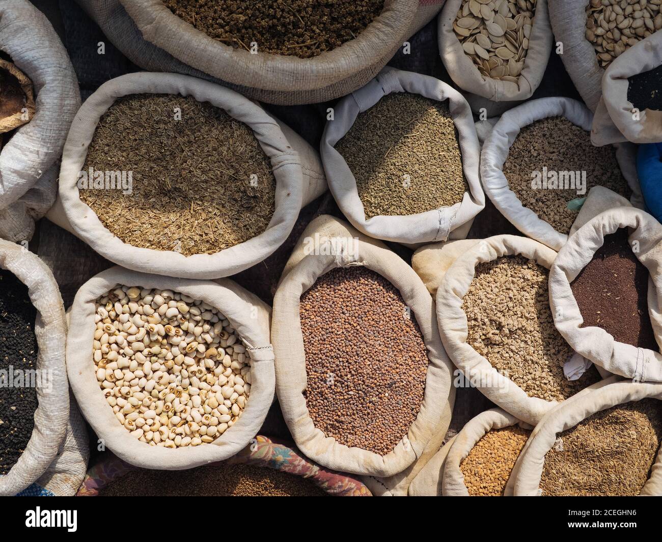 Top view fabric bags filled various grains aromatic spices condiments ...