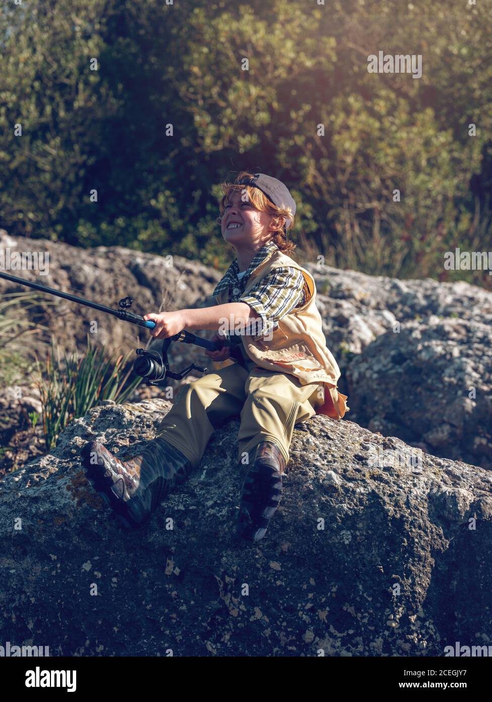 Young boy sitting and fishing Stock Photo - Alamy