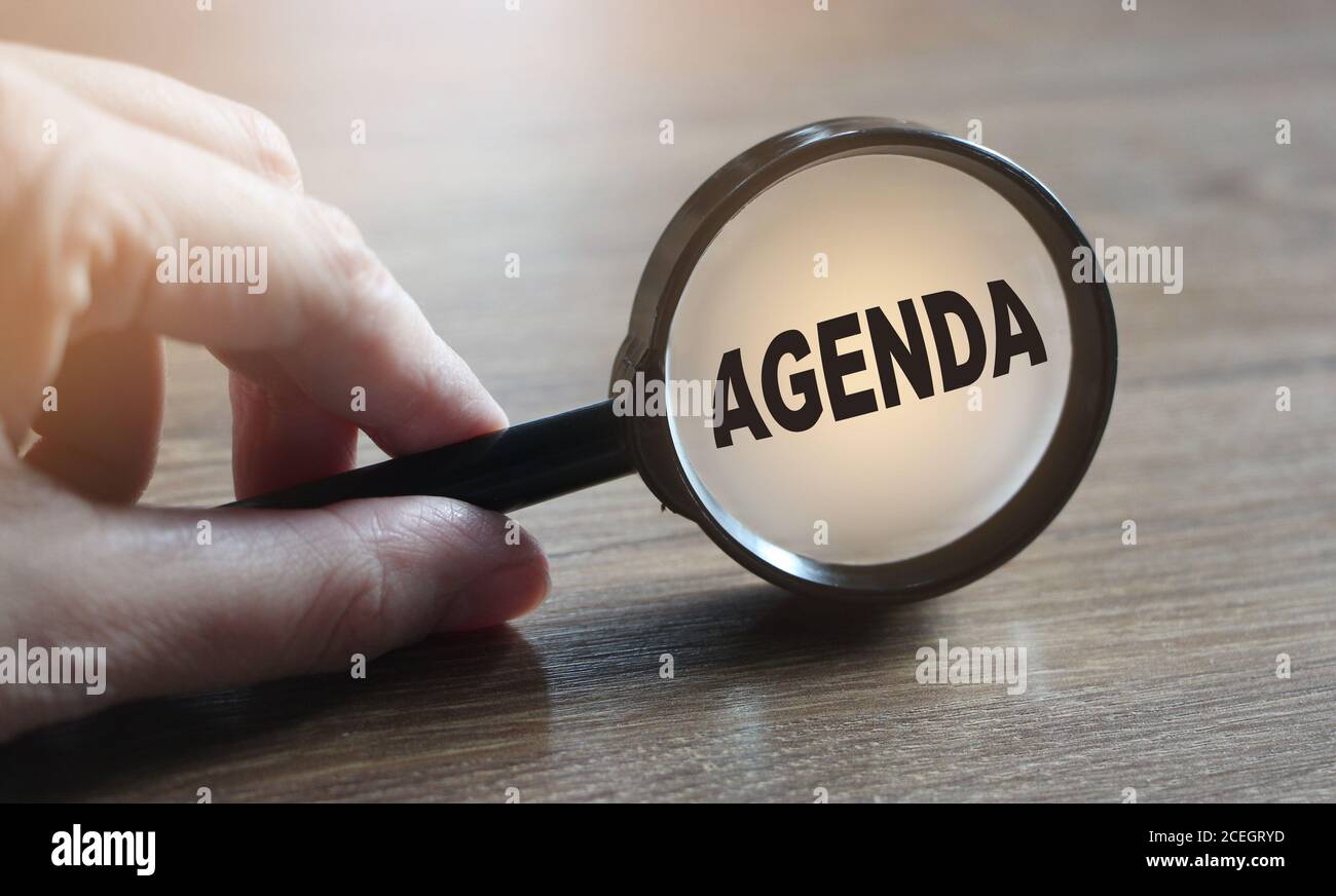 Hand Showing agenda Word Through Magnifying Glass Stock Photo - Alamy