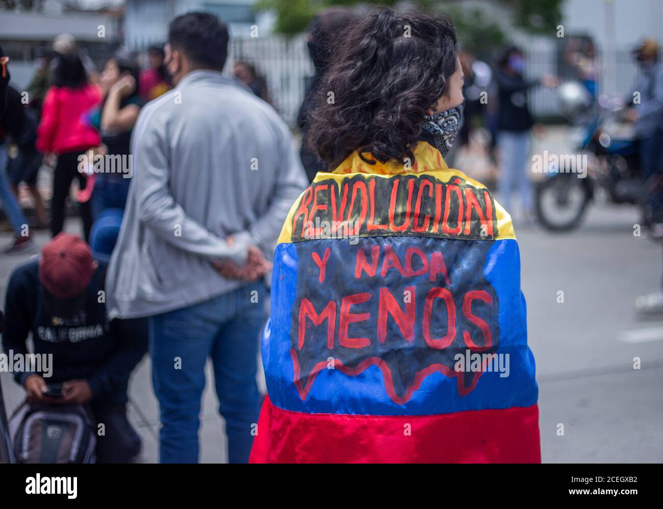 A woman wears a Colombian flag and has the message of "Revolution and ...