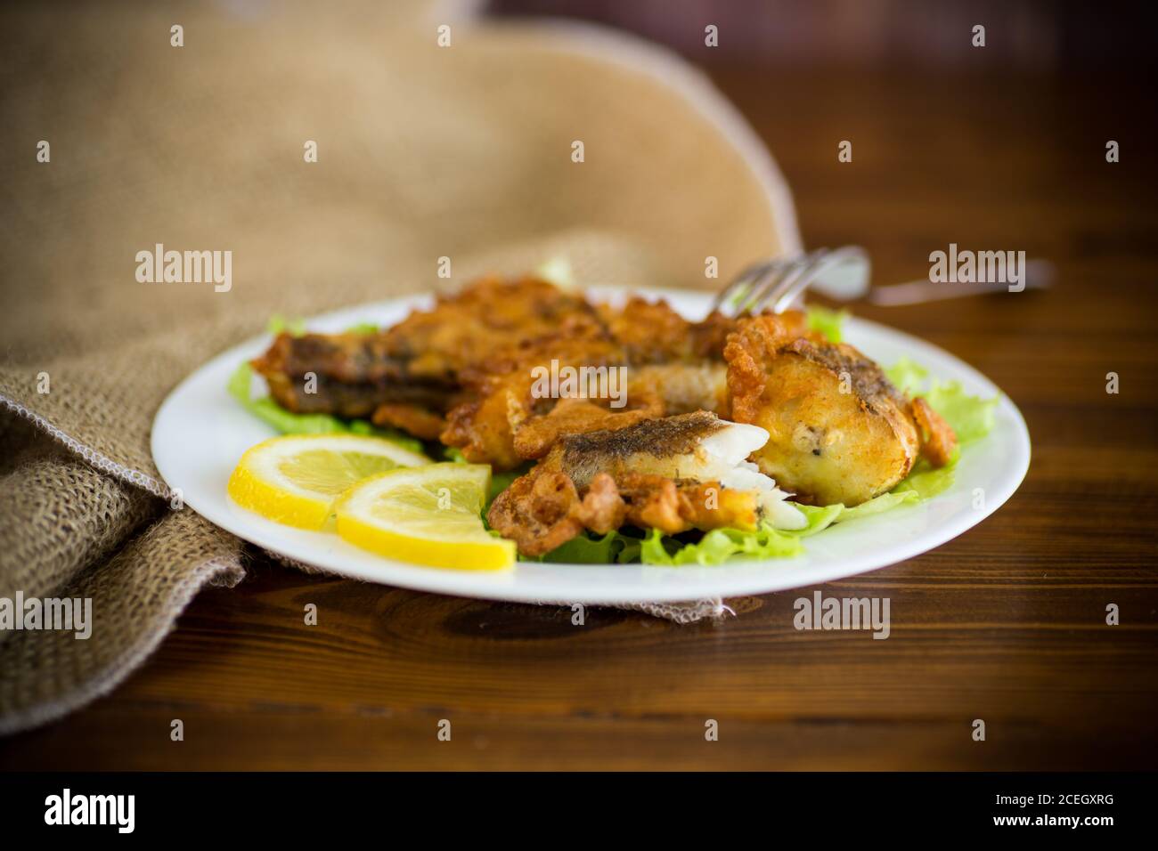 fried hake fish in batter with lettuce and lemon in a plate Stock Photo ...