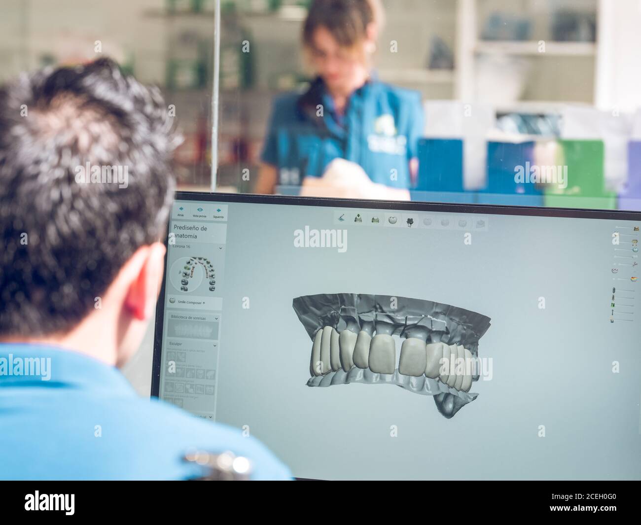 anonymous male dental technician using lab computer to model denture ...