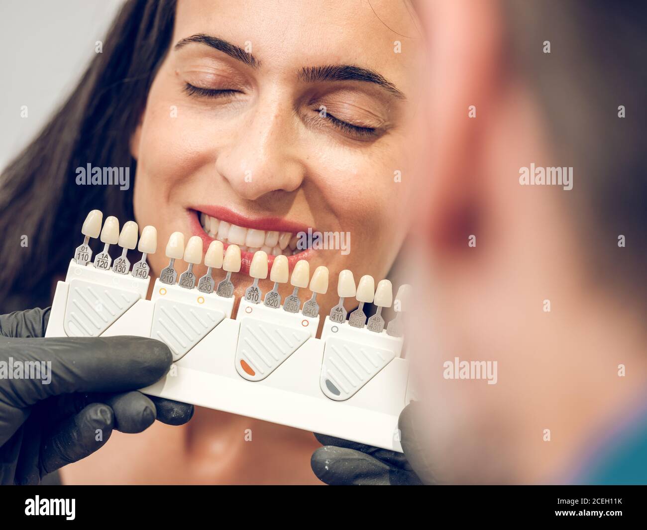 Dentist picking color of denture Stock Photo - Alamy