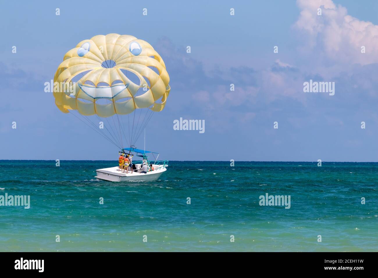 Yellow wing with happy face from skydiving pulled by a boat. Summer ...