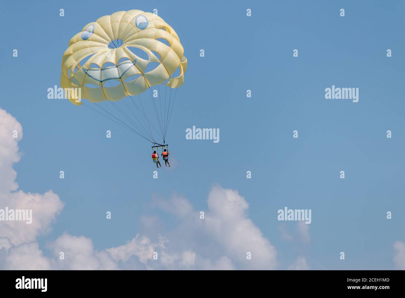 Yellow wing with happy face from skydiving pulled by a boat. Summer ...