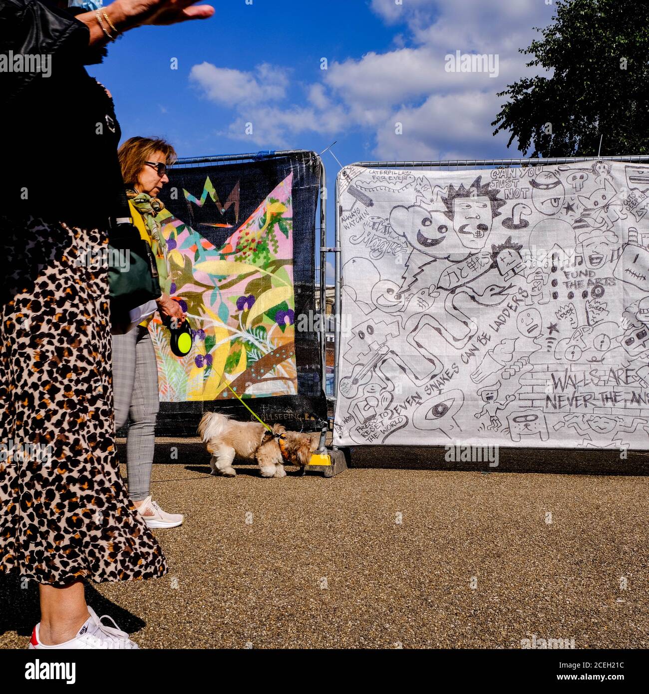 Anonymous Woman Walking Her Dog In Front Of A Colourful Painted ...