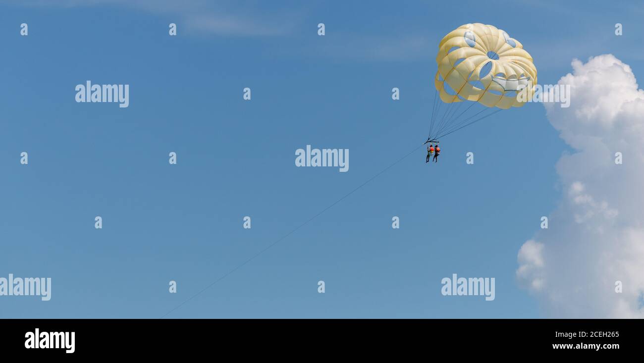 Yellow wing with happy face from skydiving pulled by a boat. Summer ...