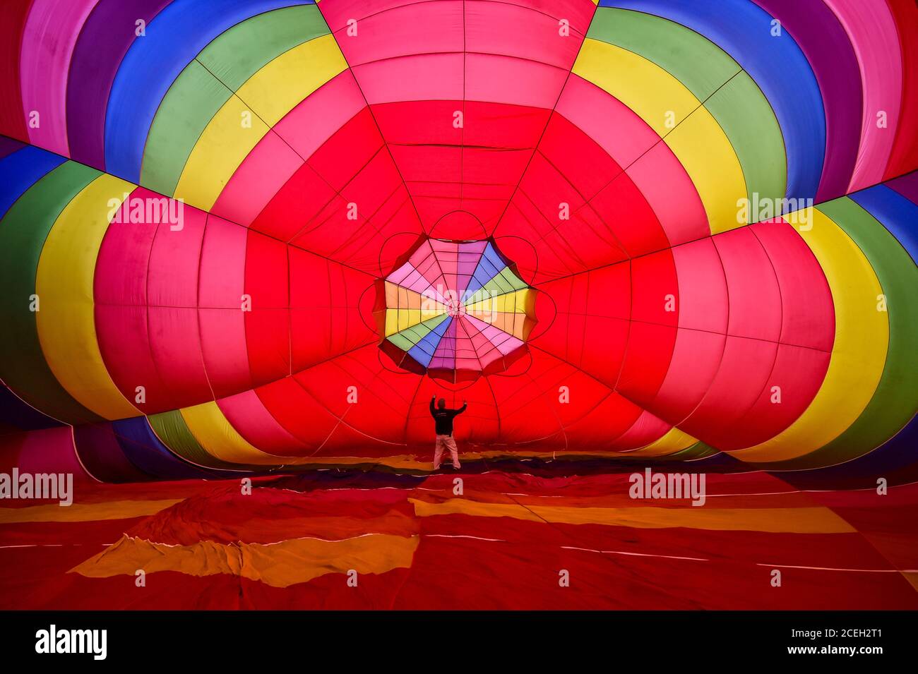 A pilot checks the rigging inside a hot air balloon before a flight ...