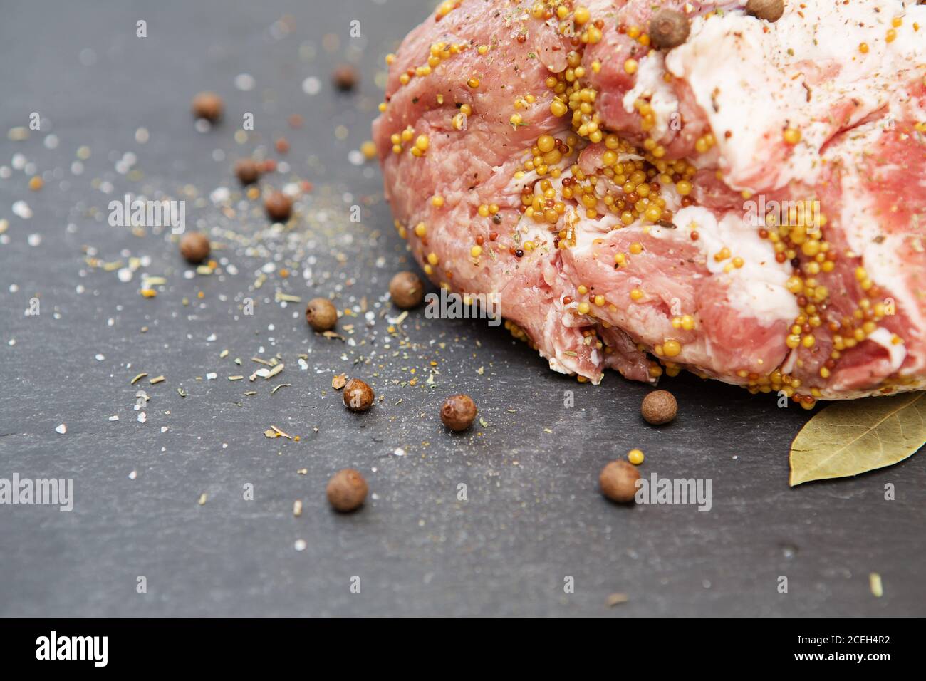 A large piece of fatty pork meat marinated with mustard, pepper and ...