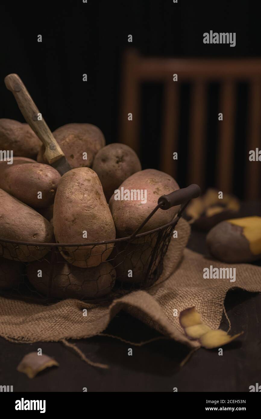 Dark and Moody, Mystic Light food photography. Potato being peeled with ...