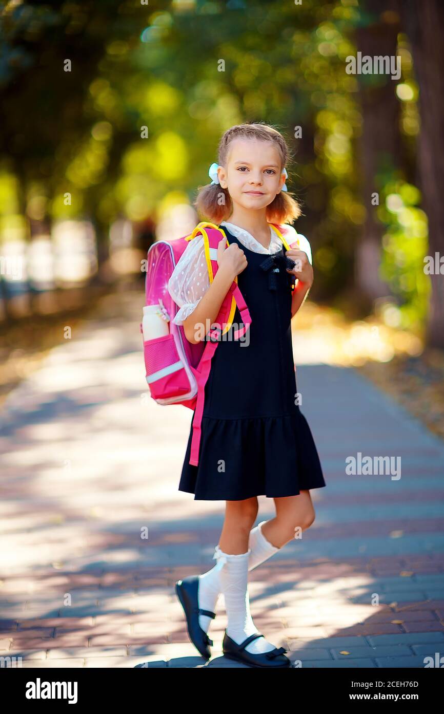 Beautiful little girl with backpack walking in the park ready back to ...