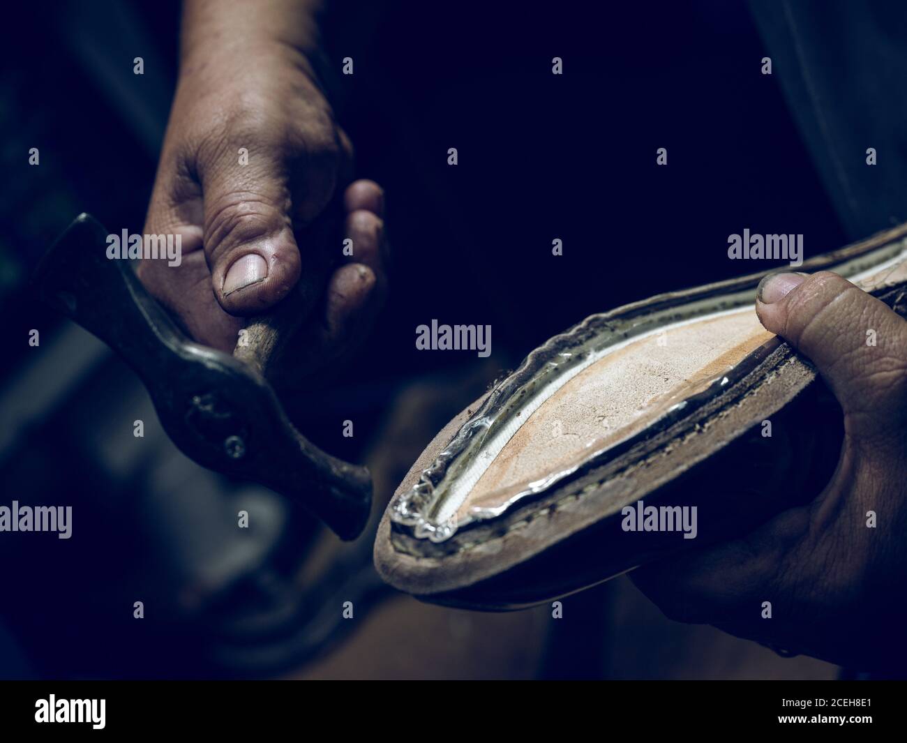 Crop shoemaker hammering nails into shoes Stock Photo - Alamy
