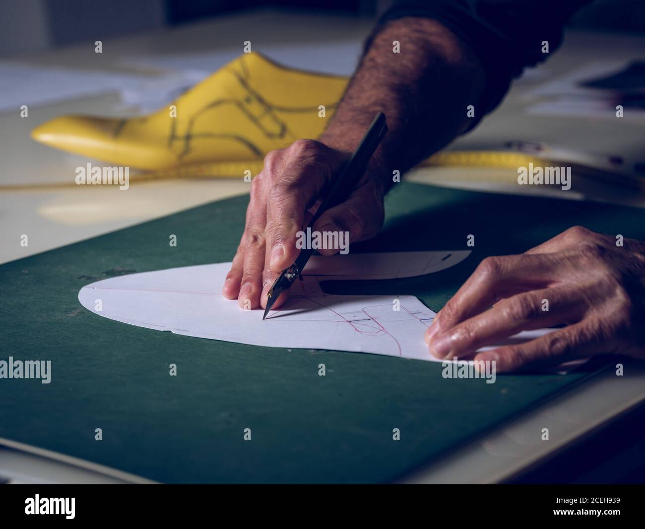 Crop hands cutting shoe template Stock Photo - Alamy