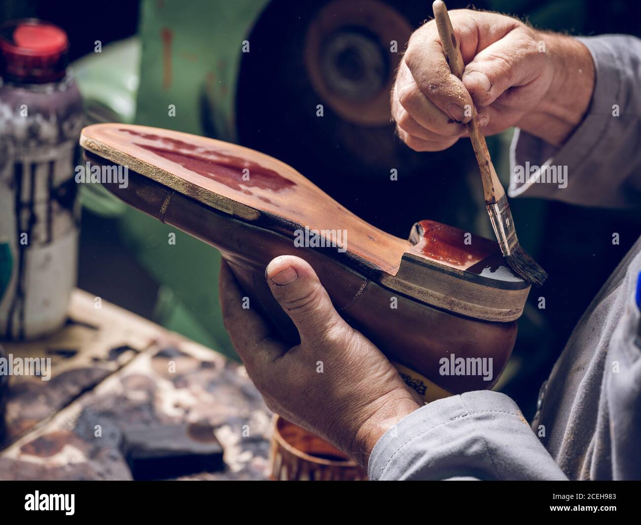 Crop shoemaker painting sole of footwear Stock Photo - Alamy
