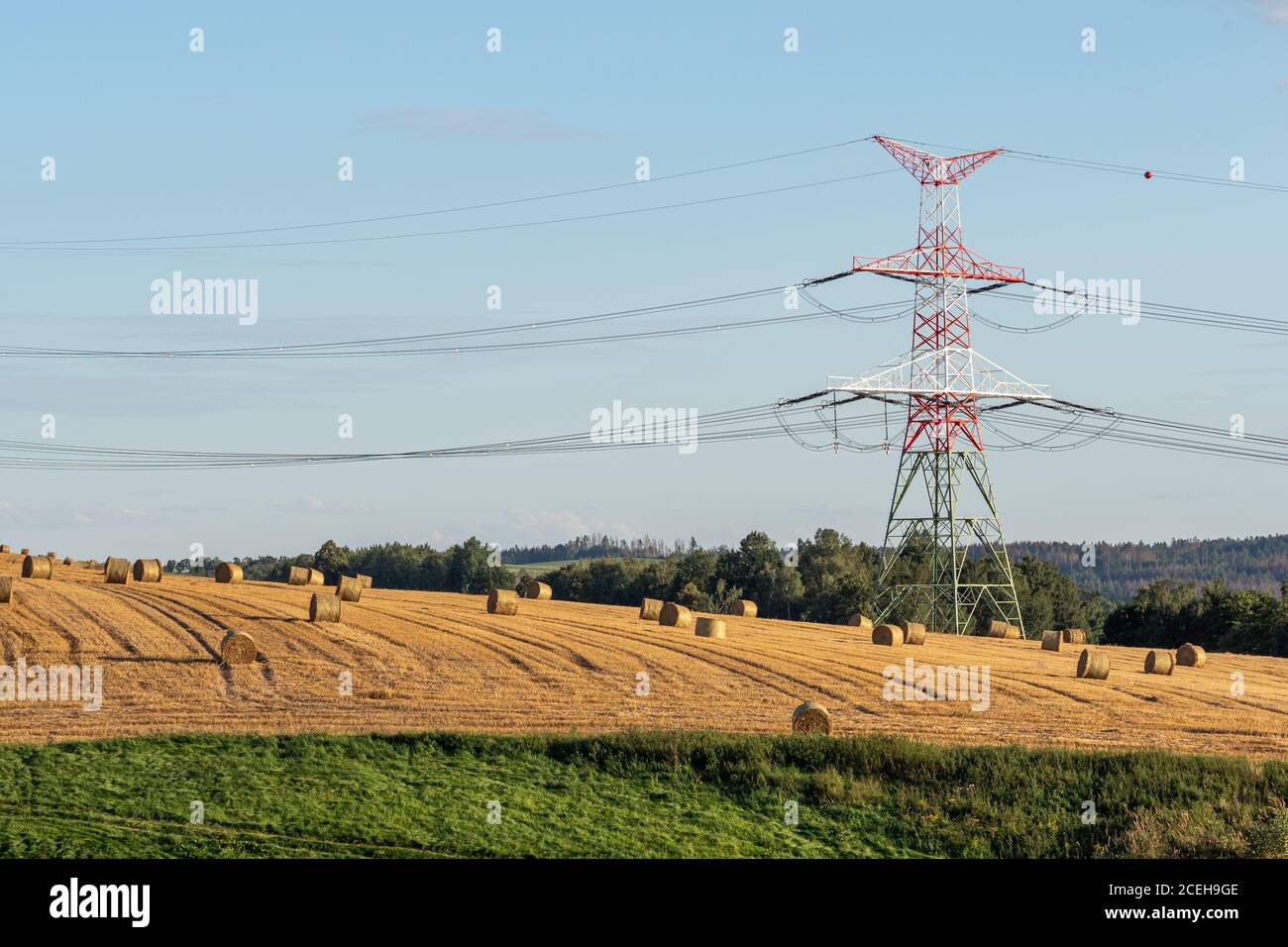 Straw bales on the field near high electricity pylons Stock Photo - Alamy