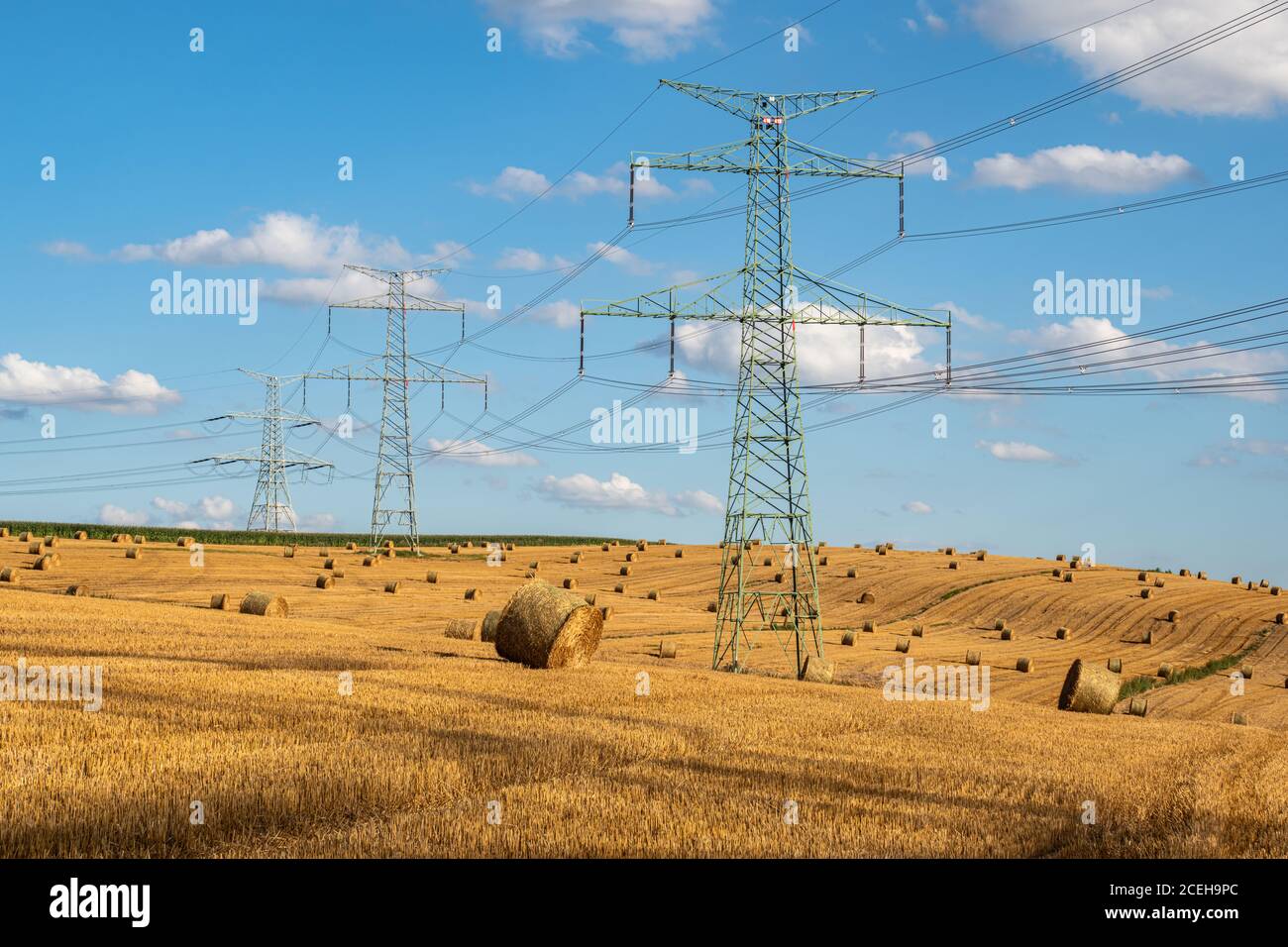 Straw bales on the field near high electricity pylons Stock Photo - Alamy
