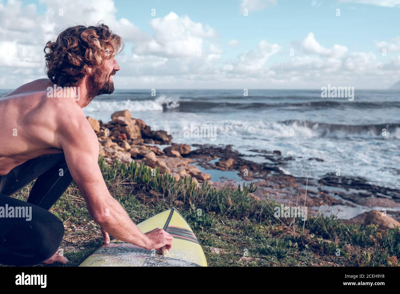 Young man cleaning surf board Stock Photo - Alamy