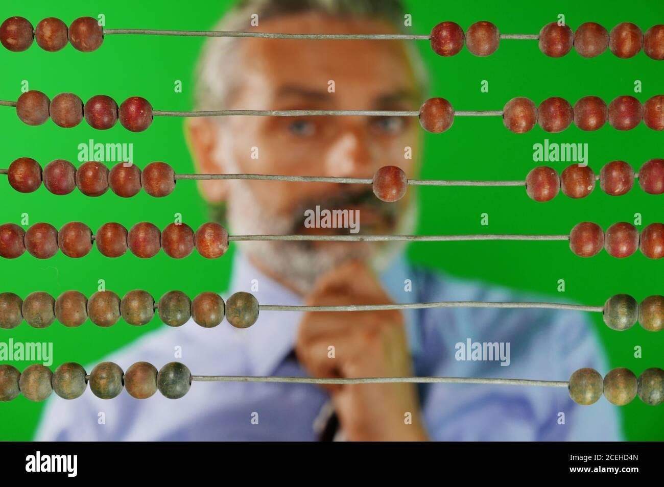 accountant holding an abacus over green background Stock Photo - Alamy