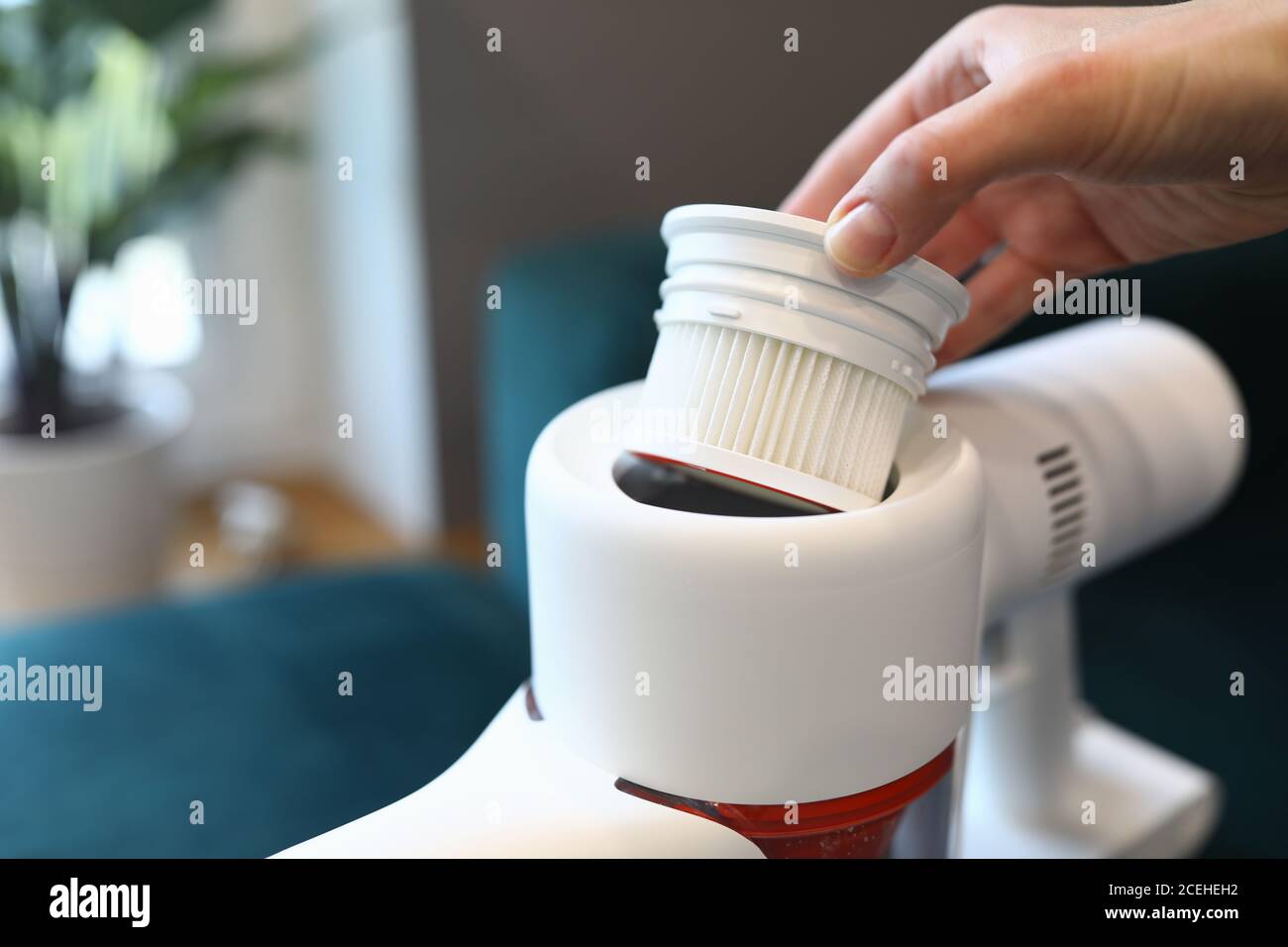 Female hand pull out white filter from white vacuum cleaner close up ...