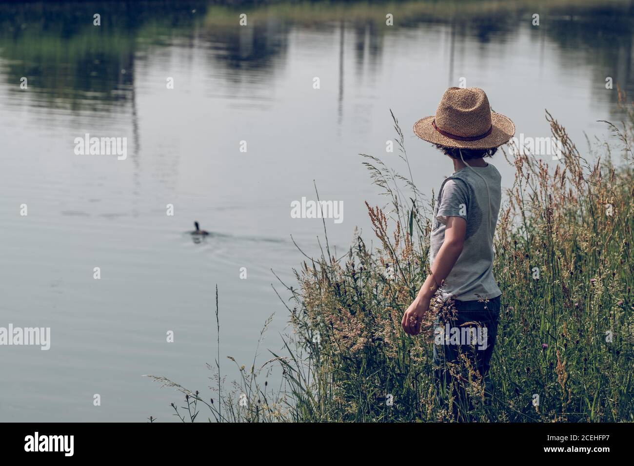 Little boy standing near water Stock Photo - Alamy