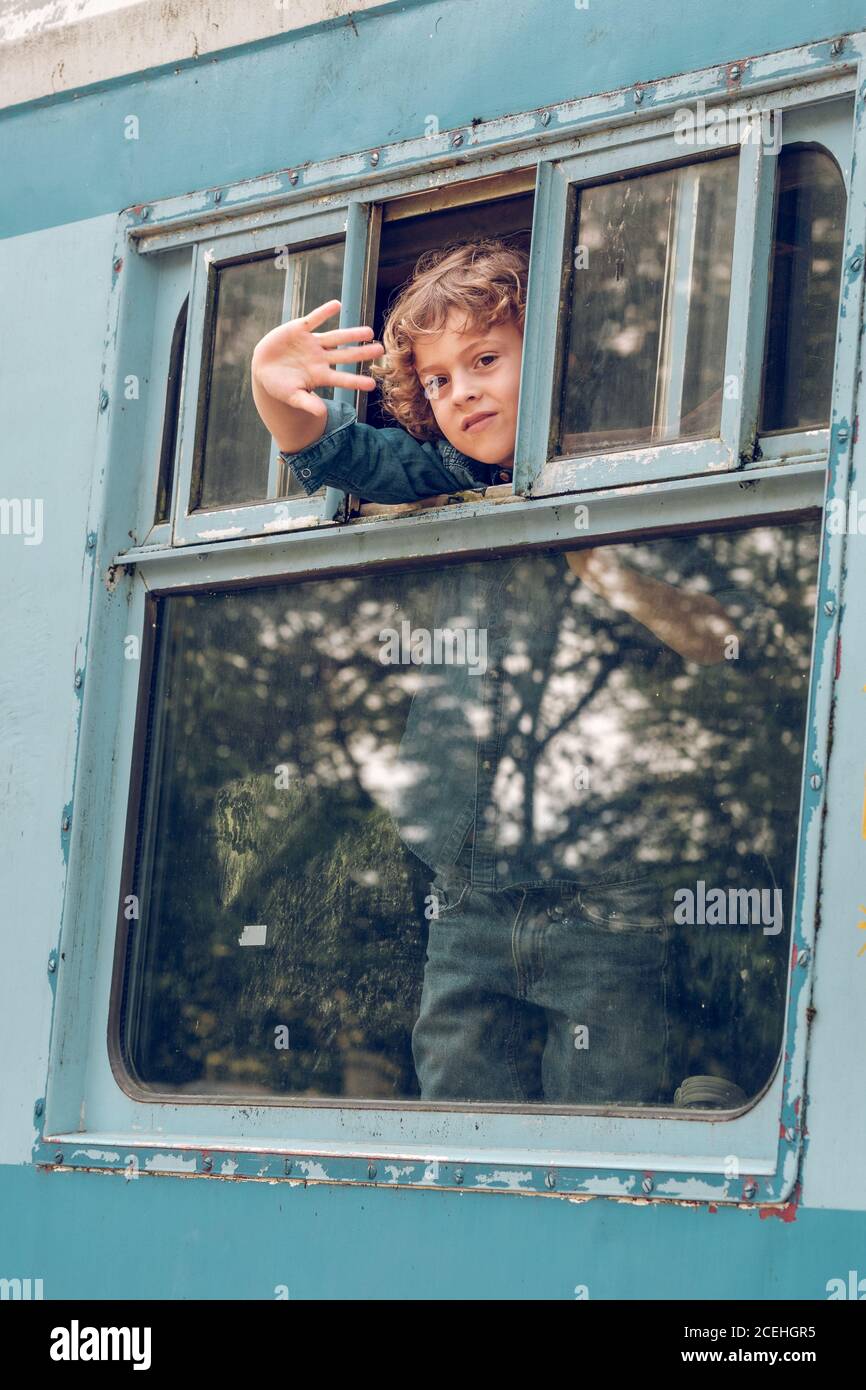 Playful child looking out of window Stock Photo - Alamy