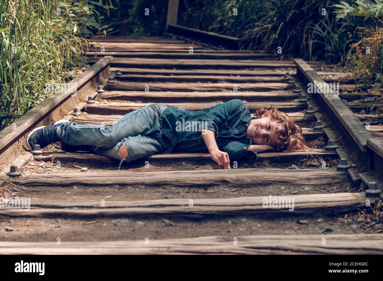 Dirty boy sleeping on railroad Stock Photo - Alamy