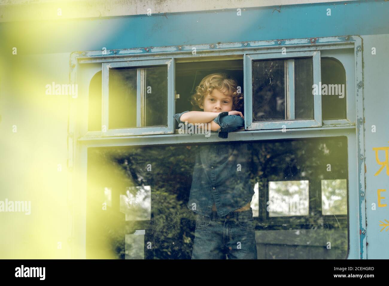 Playful child looking out of window Stock Photo - Alamy