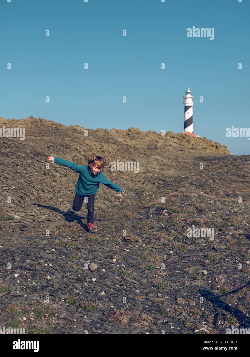 Cheerful boy running at lighthouse Stock Photo - Alamy