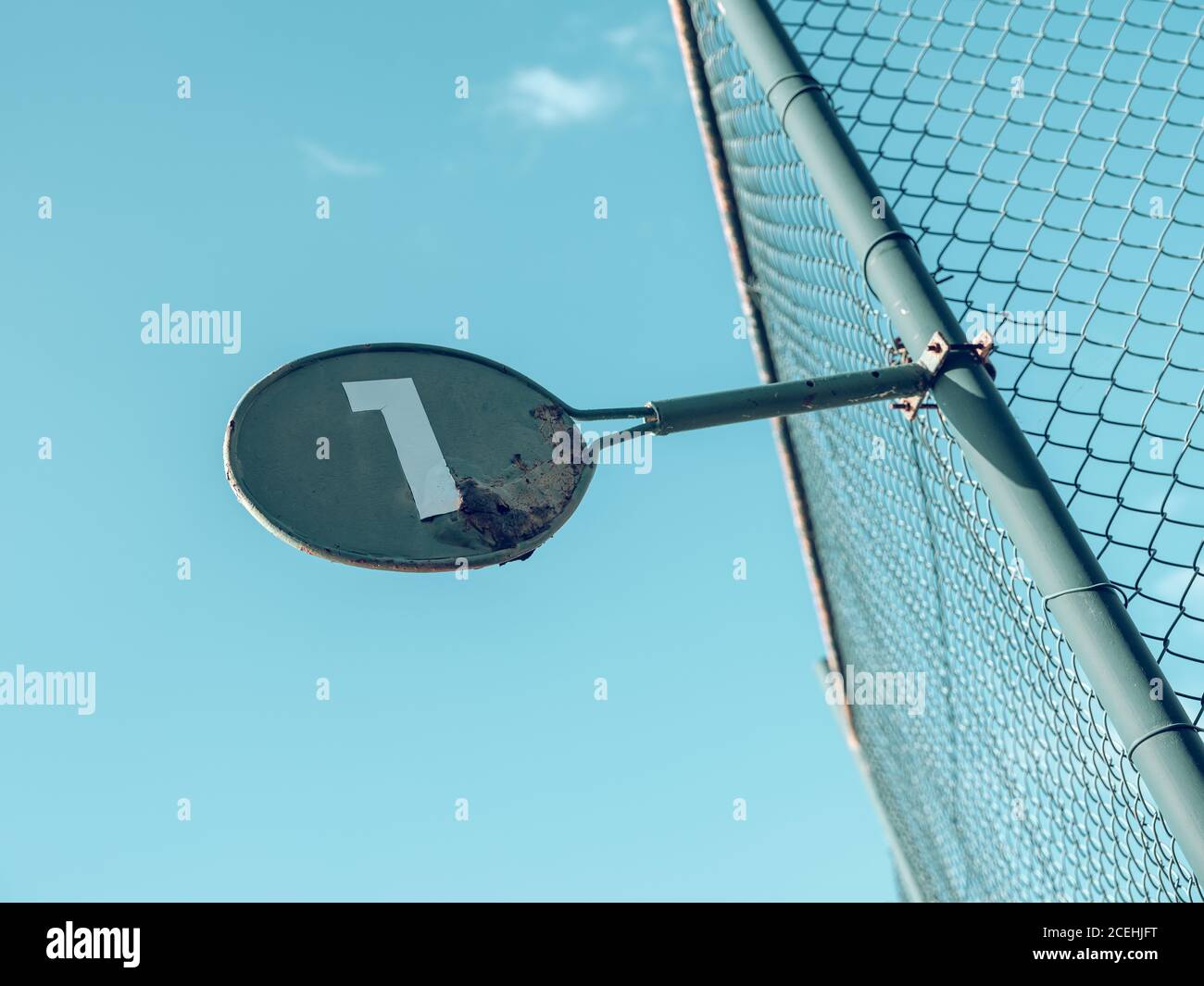 From below sign with one number near chain link fence and beautiful ...