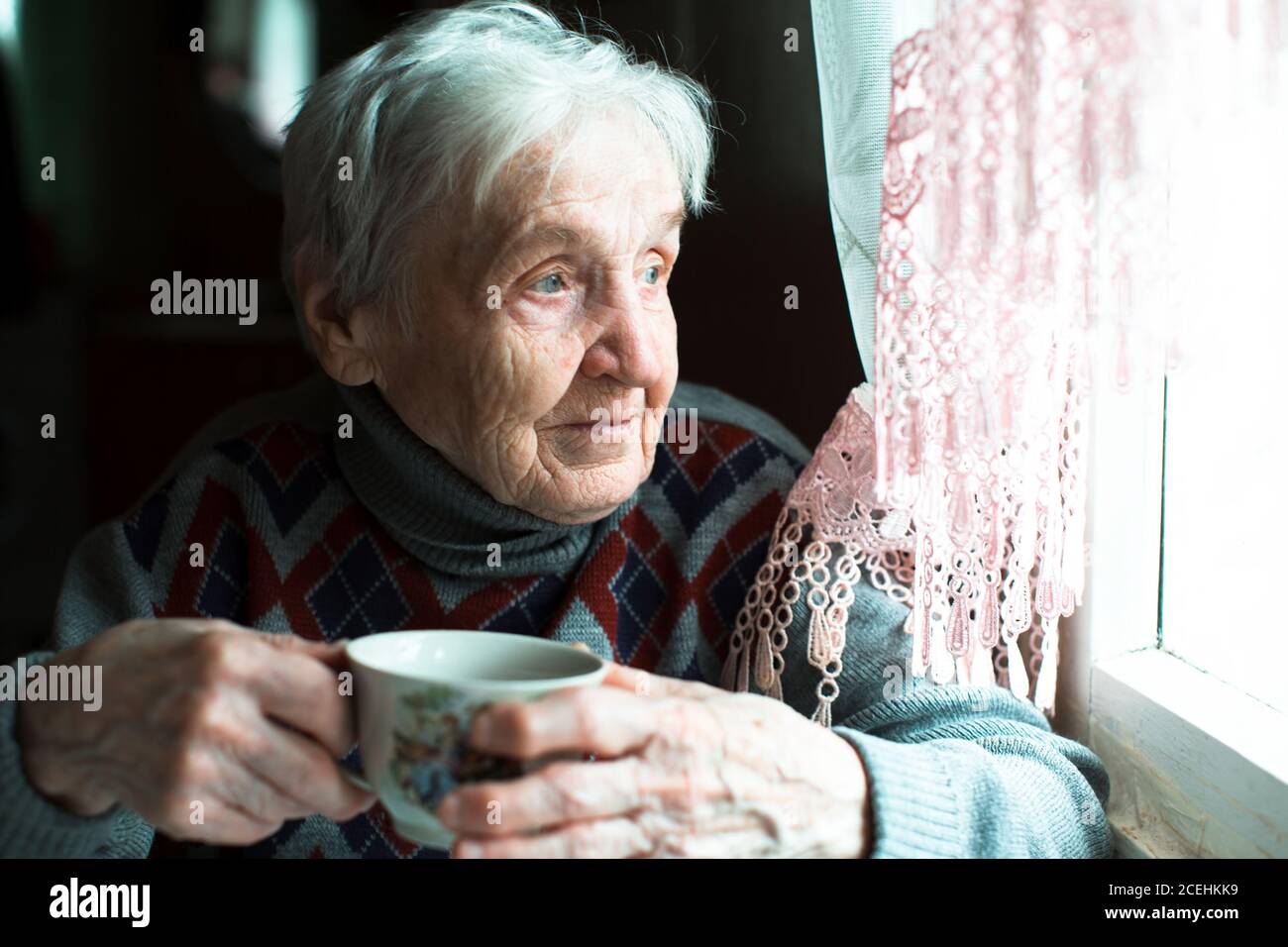 An old woman drinking tea sitting in the kitchen Stock Photo - Alamy