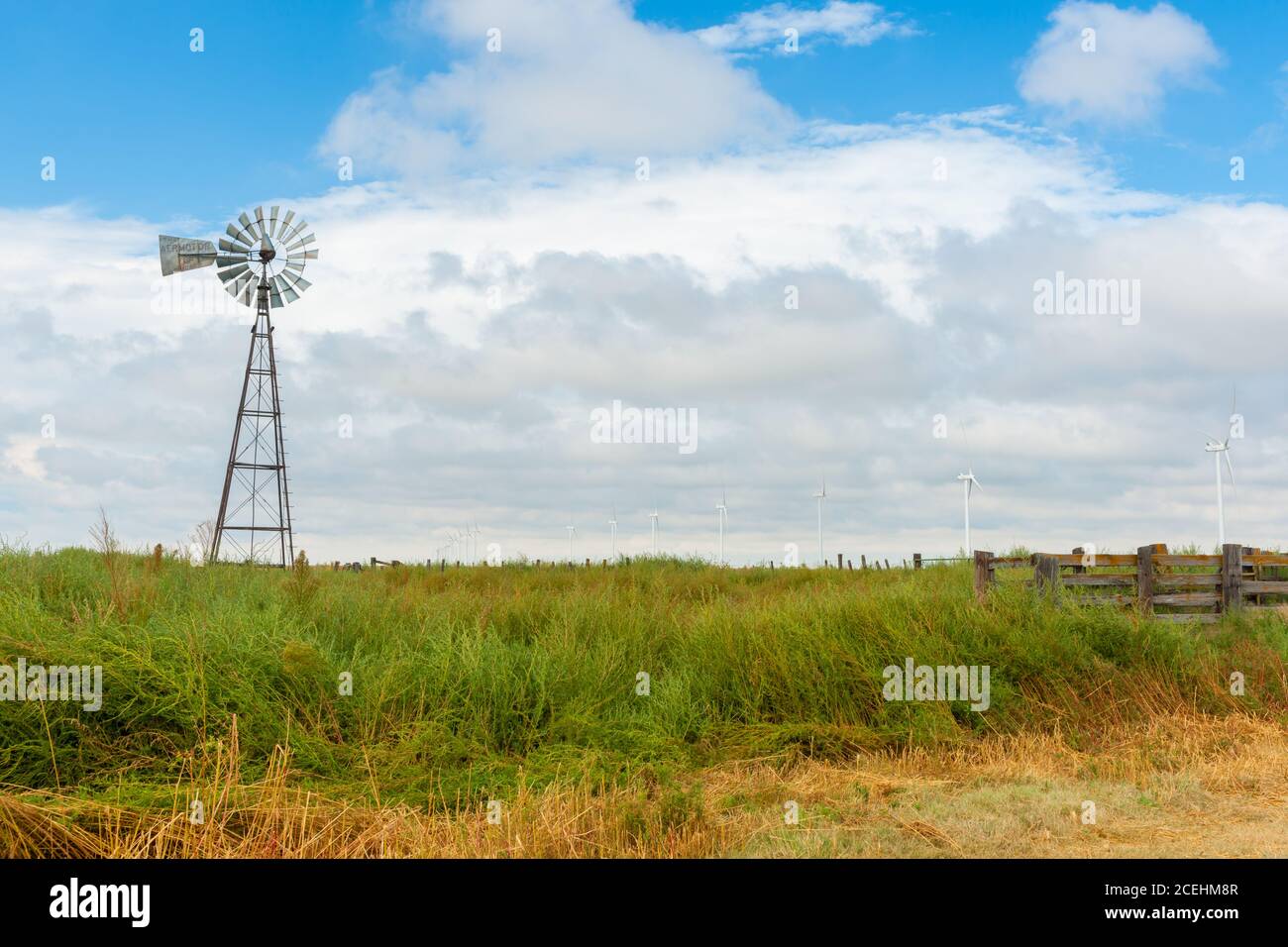 Modern power windmills and old fashioned pump windmill in field, on ...