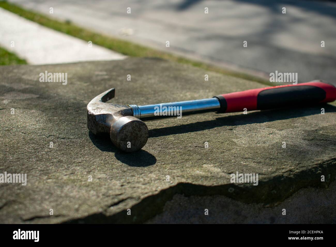 A Hammer With a Red and Black Handle on a Cobblestone Pillar on a ...