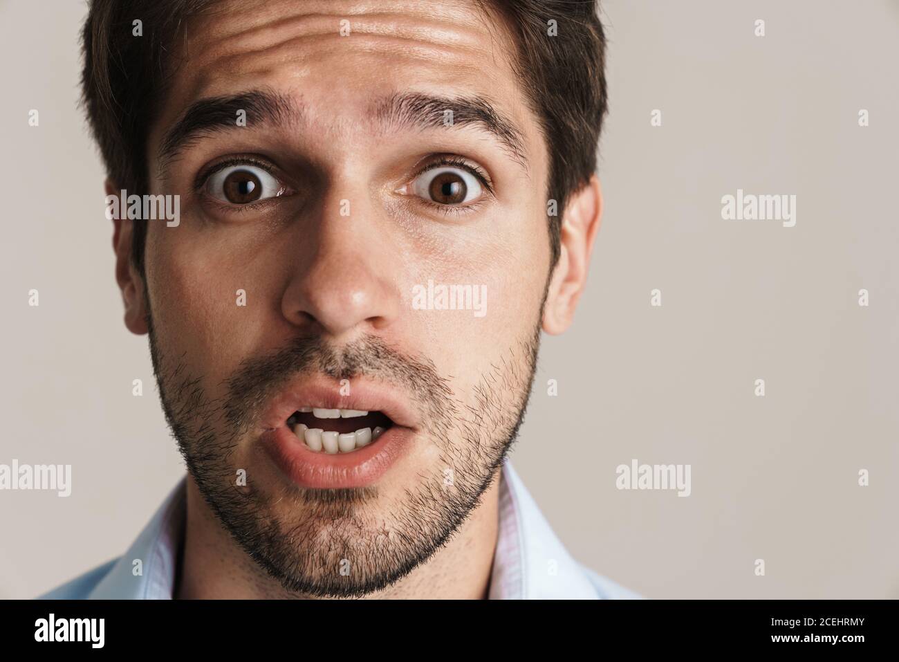 Image of scared businesslike brunette man expressing surprise on camera ...