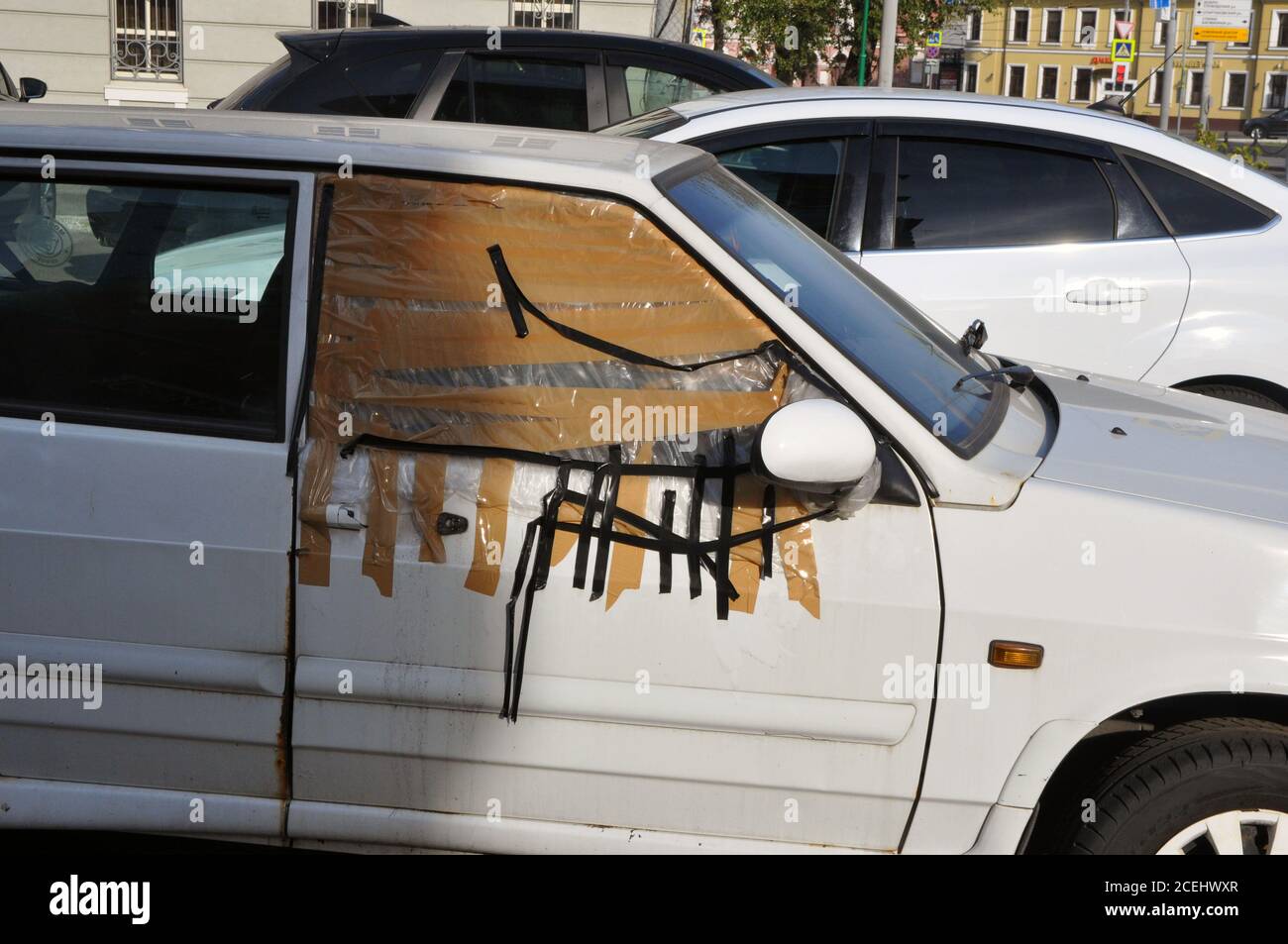 Broken right front side window of the car. Temporary sealing with tape ...