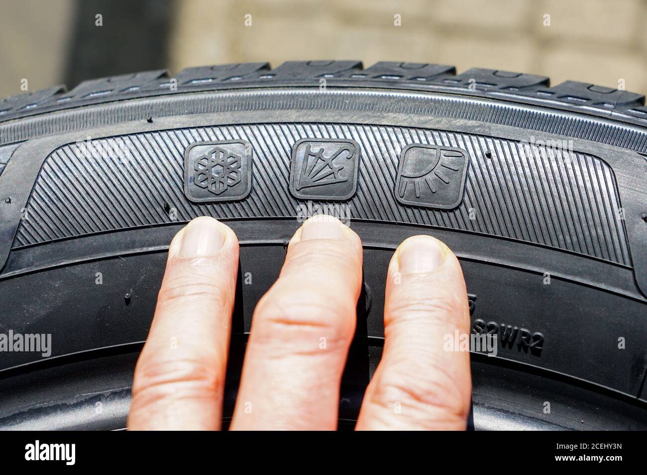 all season tire sidewall markings with images of snowflake, umbrella and sun Stock Photo - Alamy