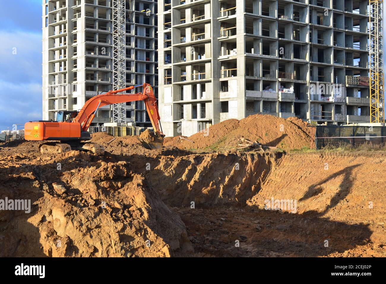 Excavator digs ground at a construction site for installing concrete ...