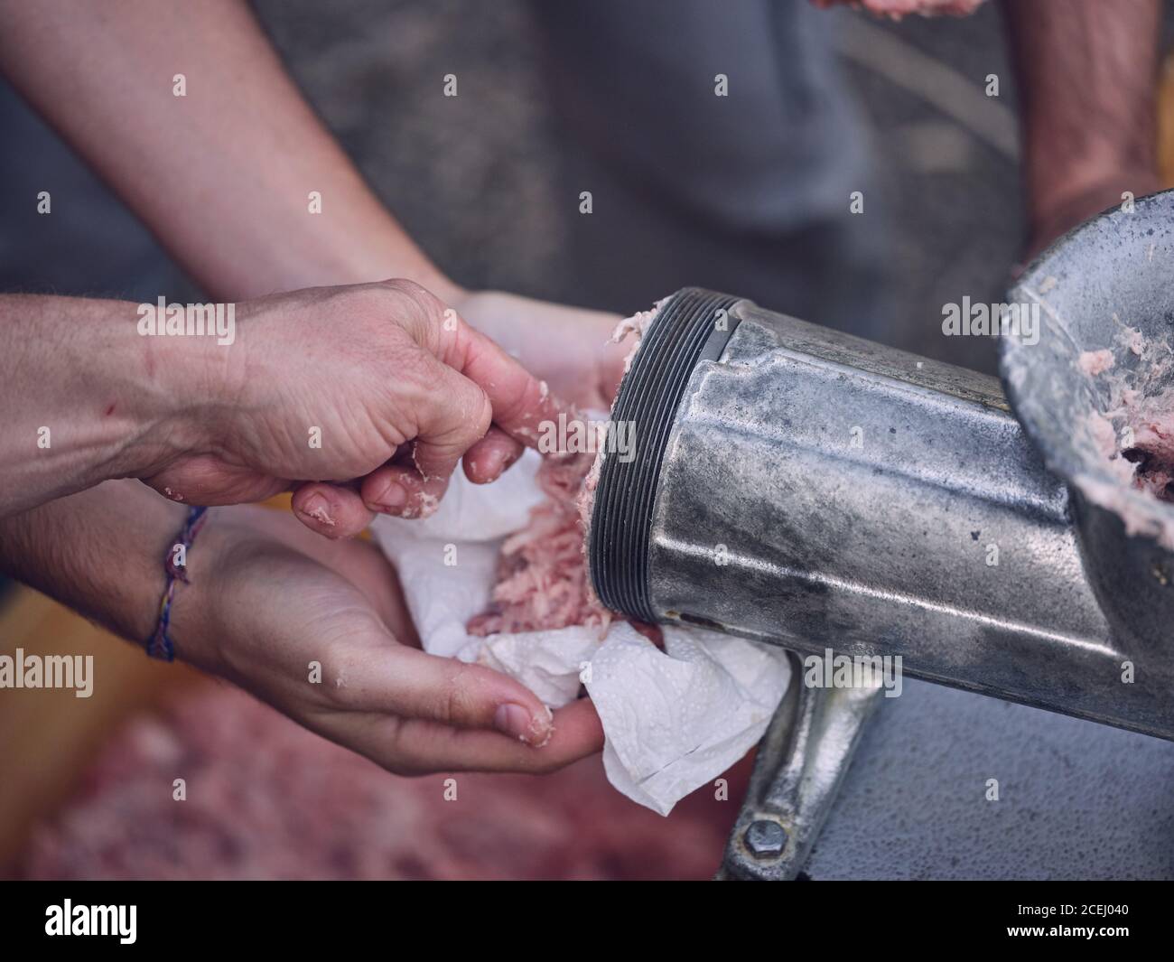 unrecognizable people working near metal machine mincing fresh meat ...