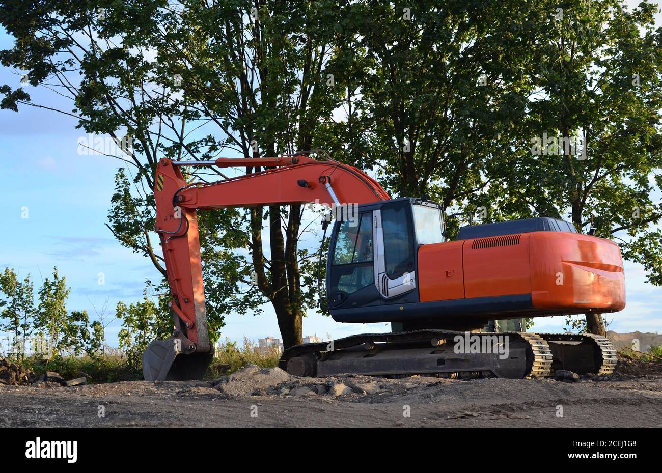 Excavator working at a construction site. Backhoe dig the ground for ...