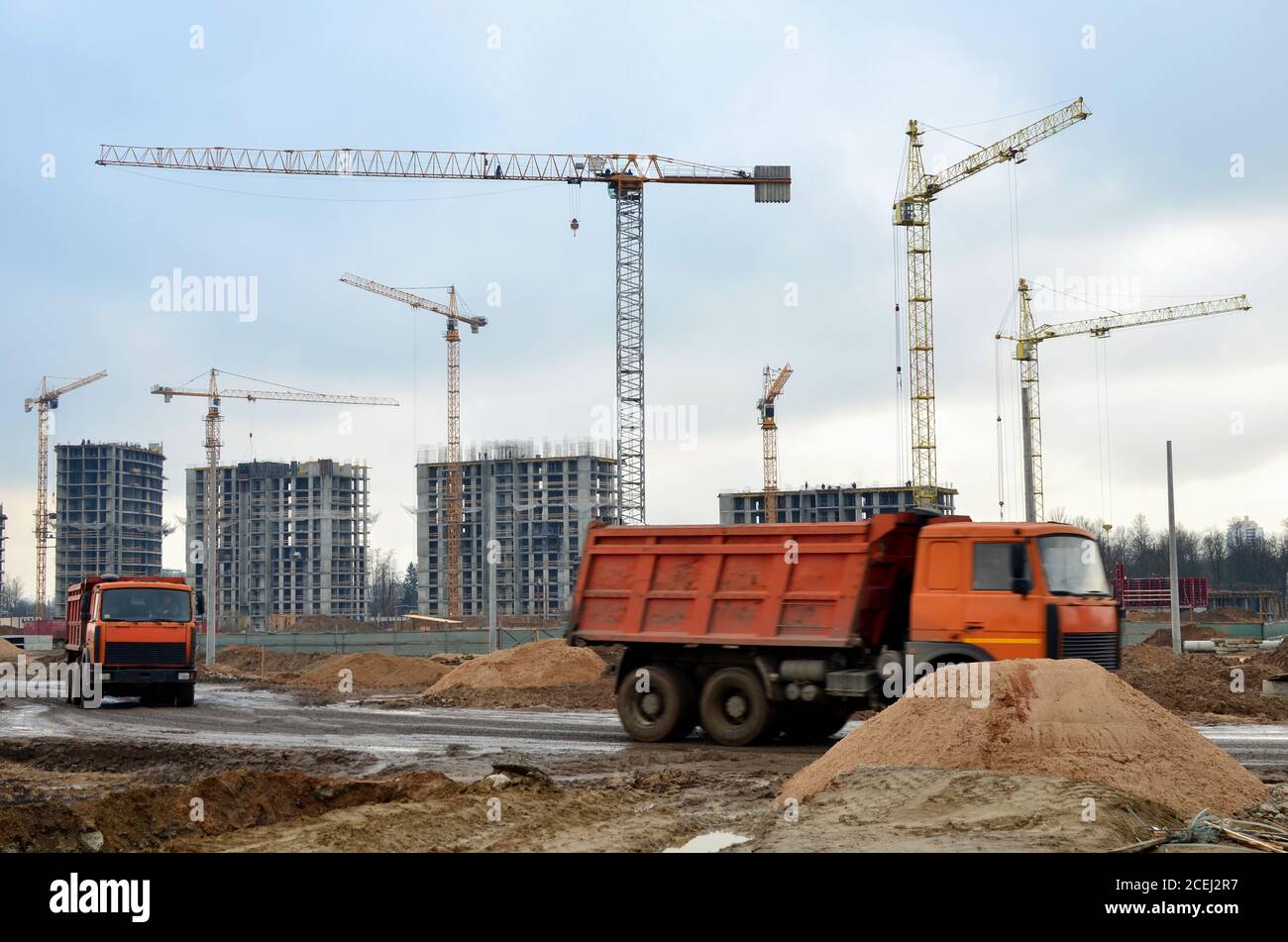 Heavy dump trucks and hydraulic luffing jib tower cranes works at a ...