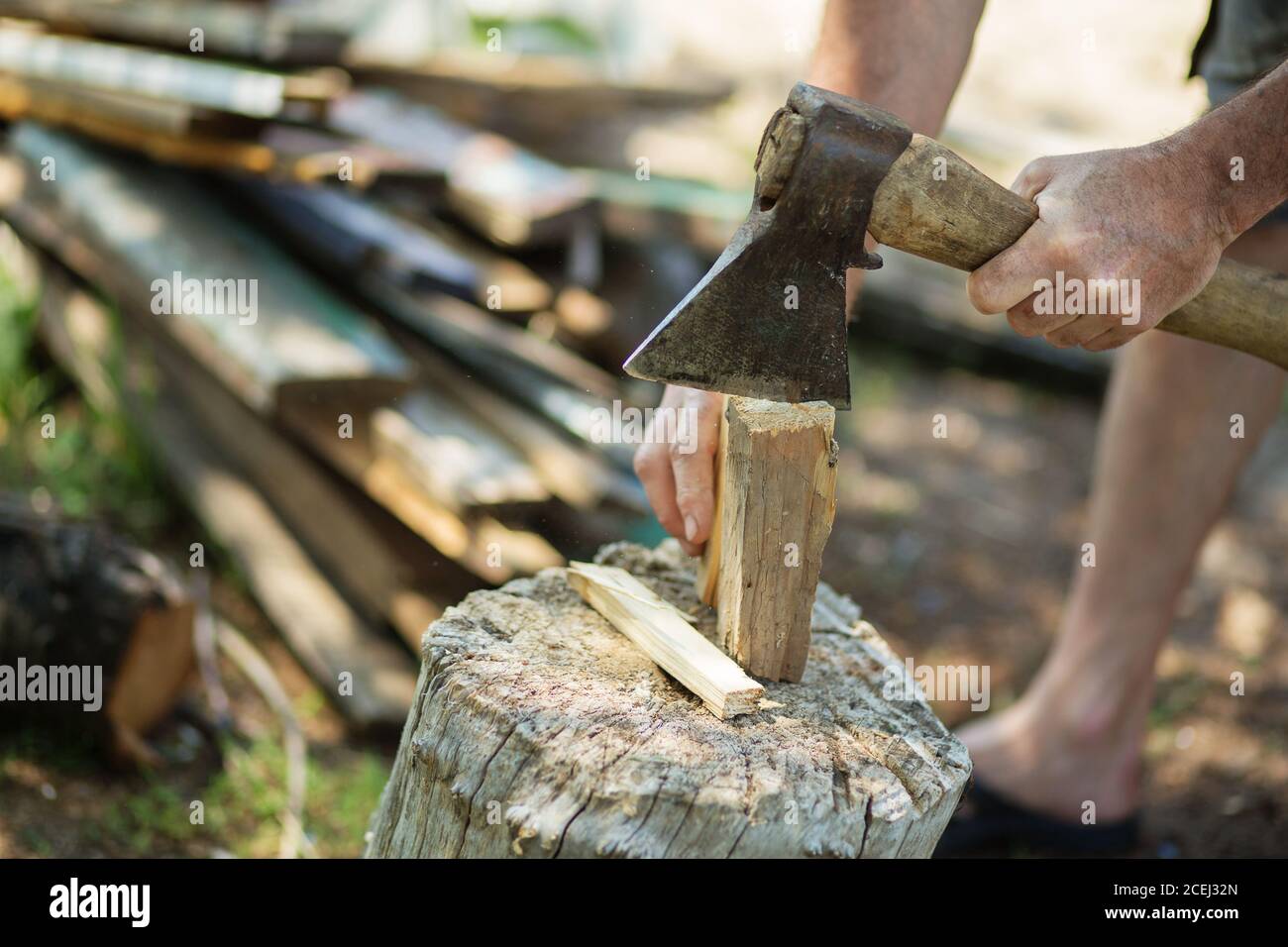 Man with an ax chops firewood. Man is chopping wood with vintage axe ...