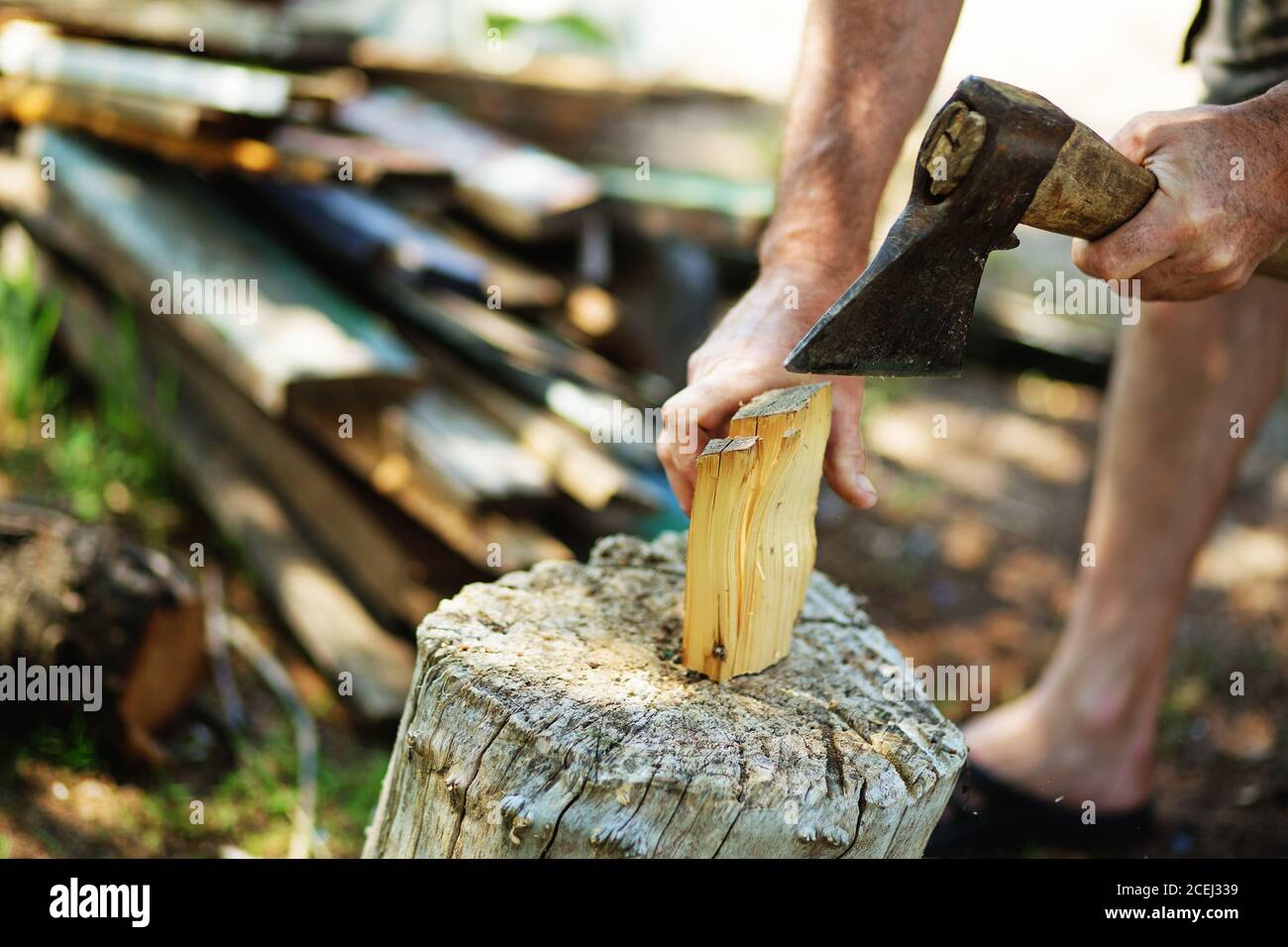 Man with an ax chops firewood. Man is chopping wood with vintage axe ...