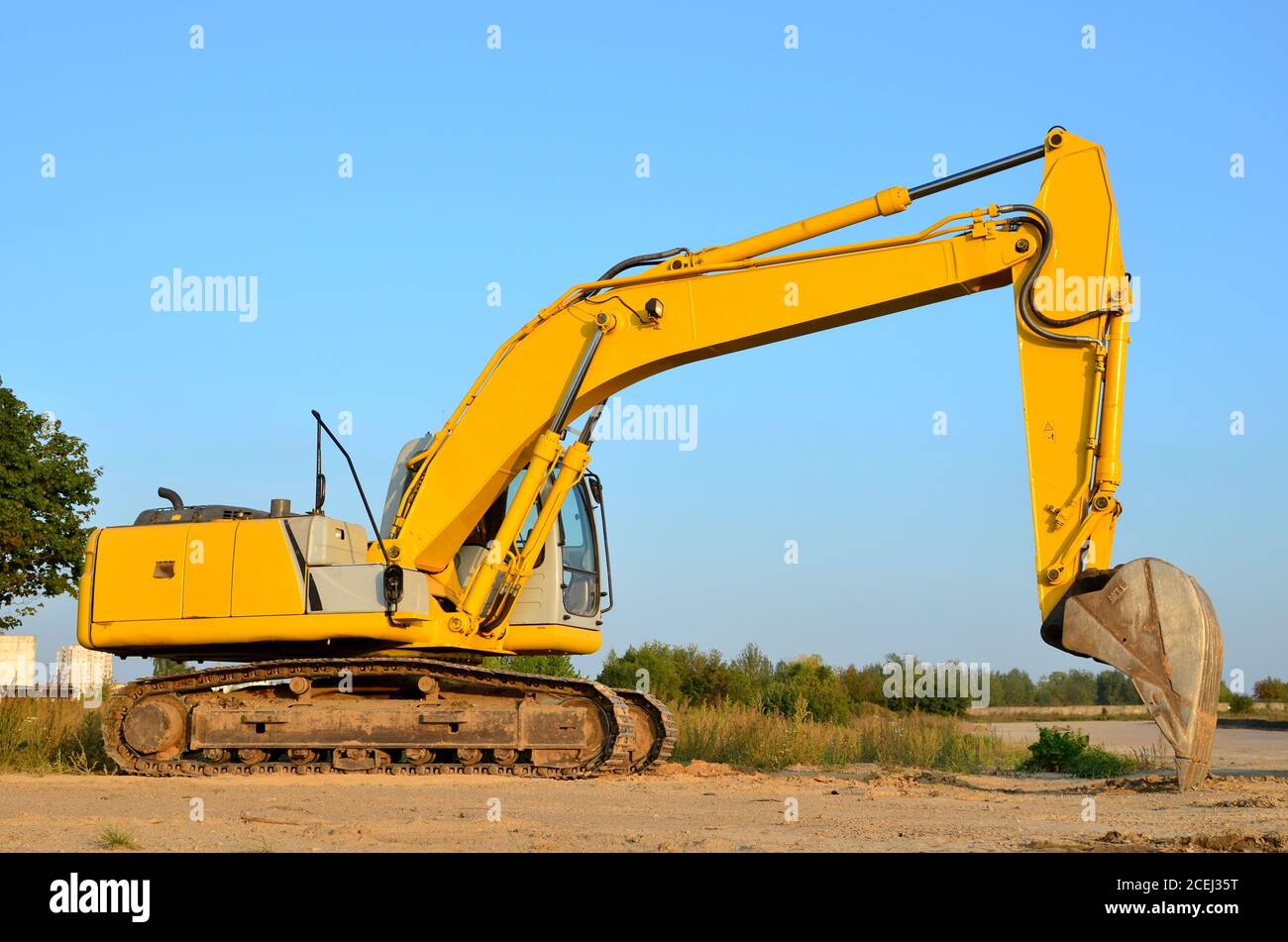 Bucked tracked excavator digs ground at a construction site for ...
