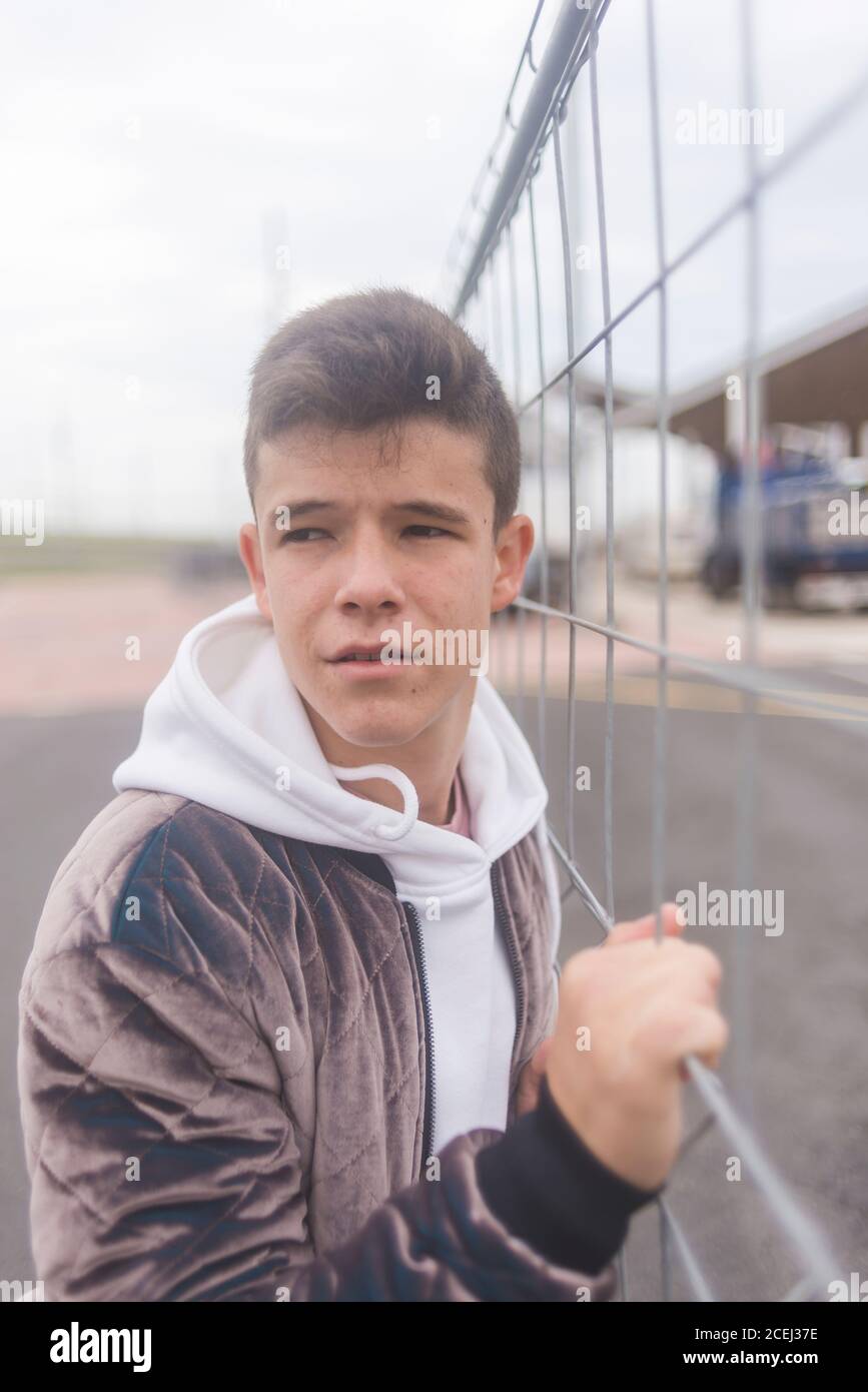 Boy leaning on fence hi-res stock photography and images - Alamy