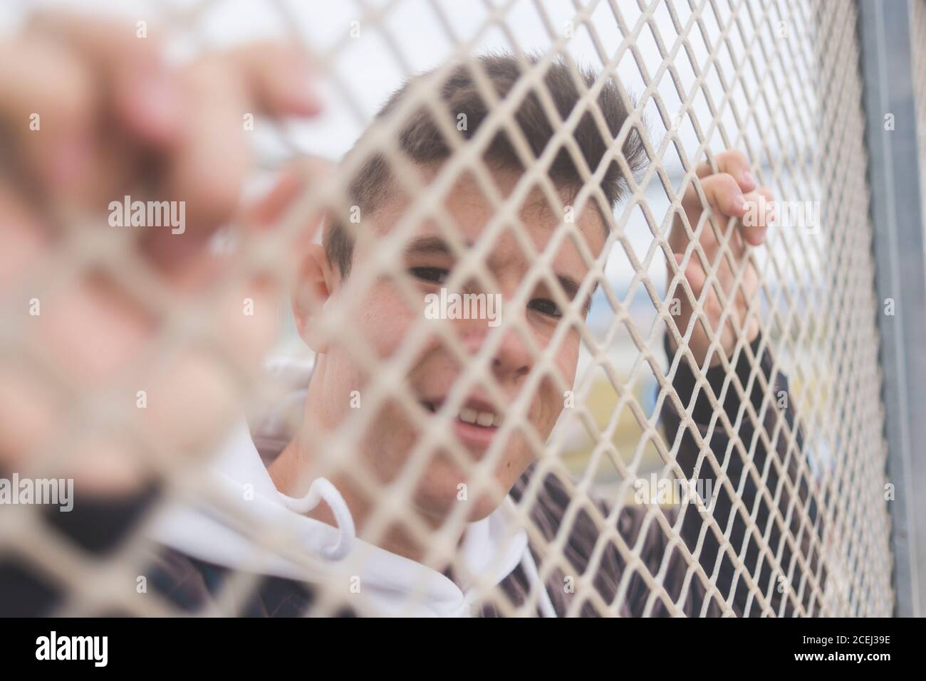 Portrait of a young teenage boy leaning on a fence in the city Stock ...