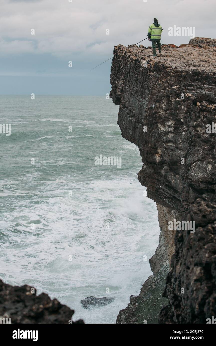 Fisherman fishing on a big cliff Stock Photo - Alamy